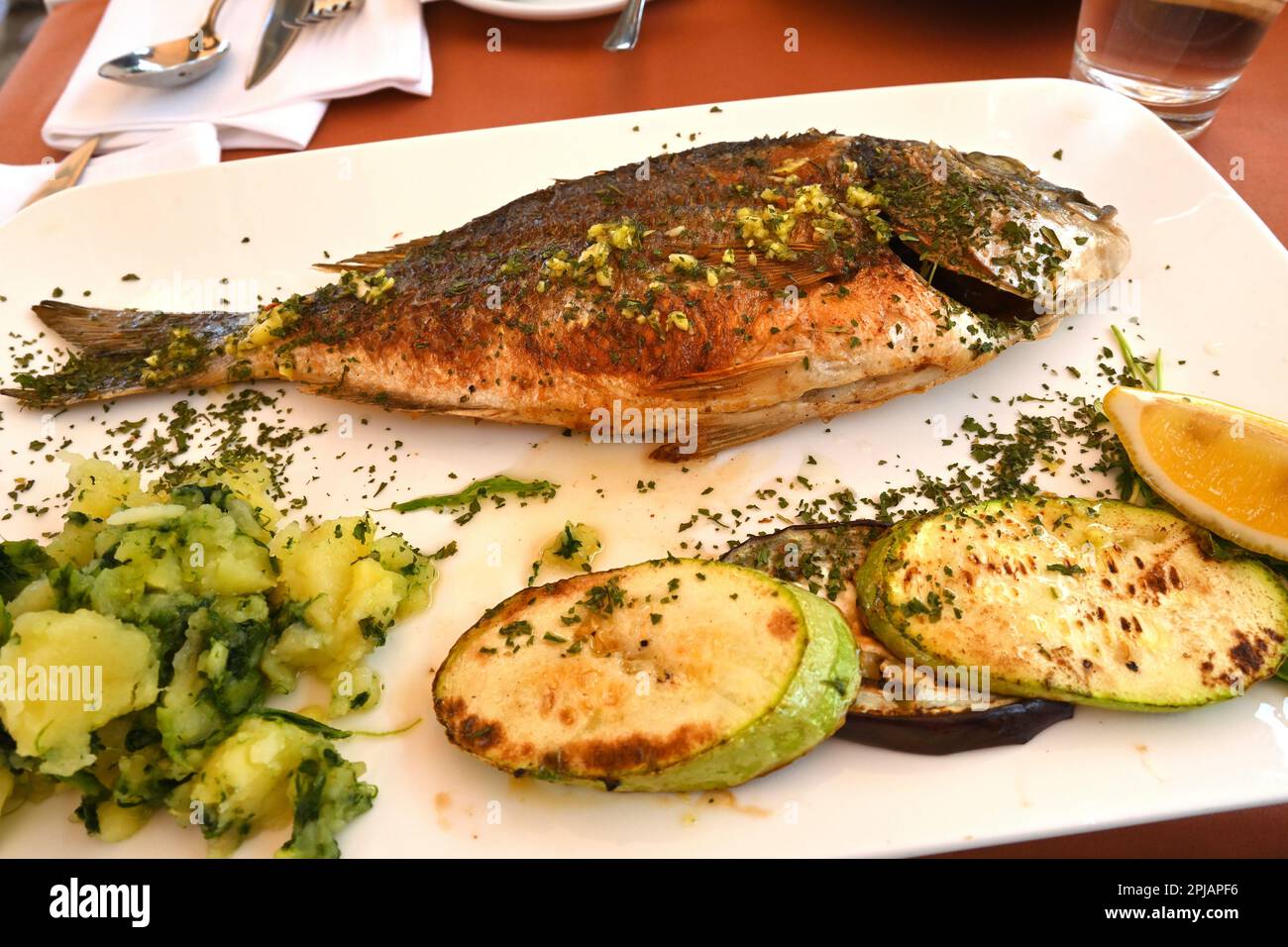 Grilled fish in garlic butter, served with zucchini and swiss chard ...