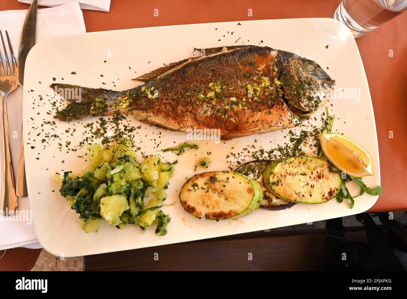 Grilled fish in garlic butter, served with zucchini and swiss chard ...