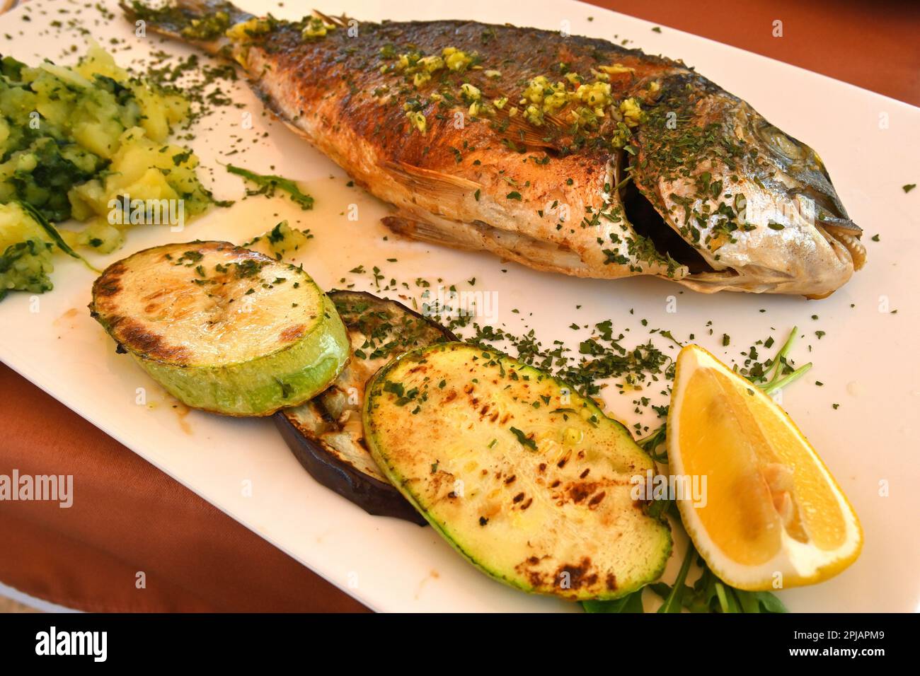 Grilled fish in garlic butter, served with zucchini and swiss chard ...