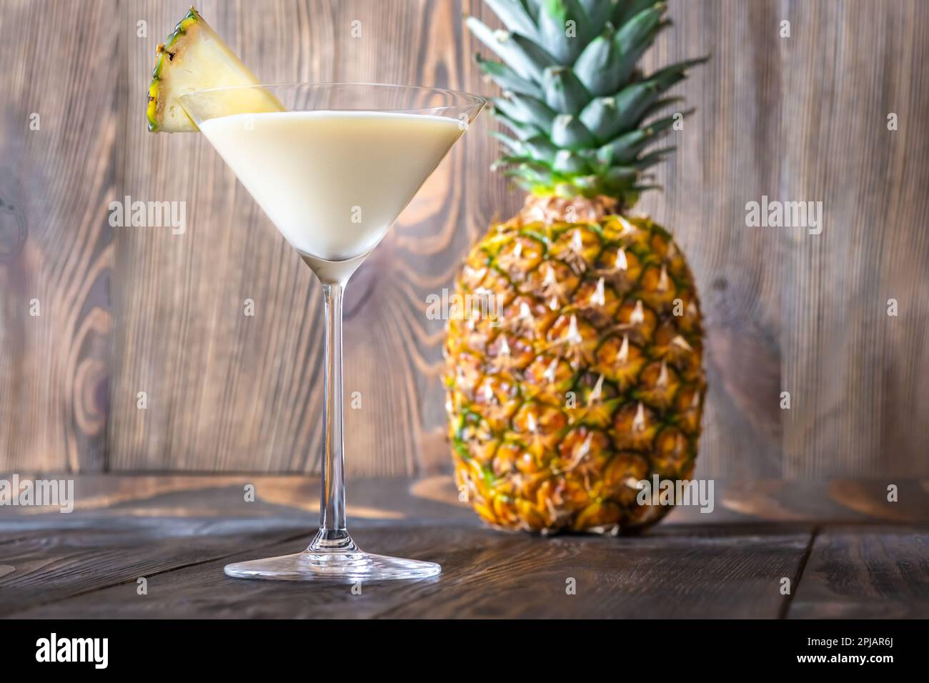 Pineapple Lassi cocktail garnished with pineapple wedge Stock Photo - Alamy