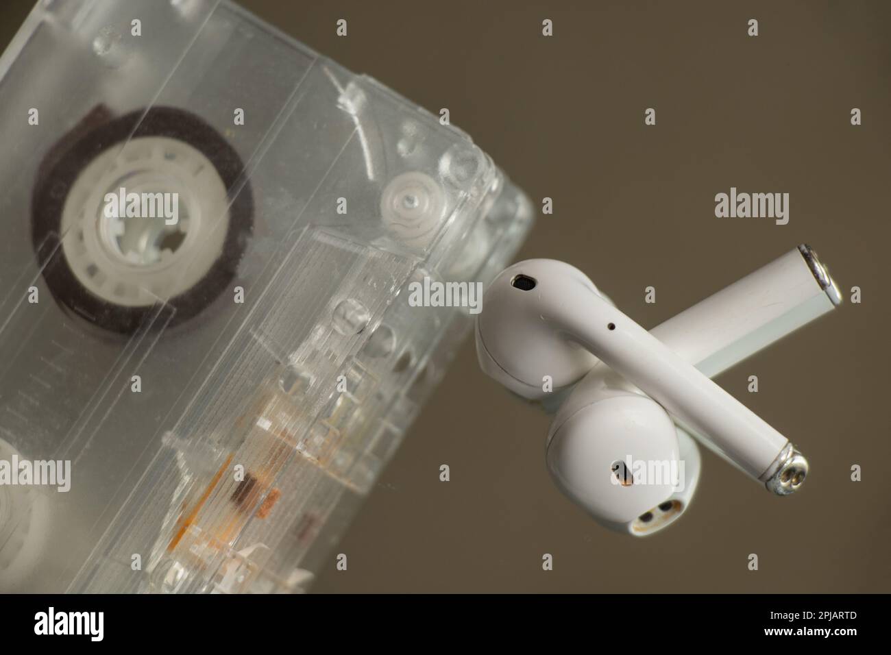 old music cassette and wireless headphones on an isolated background ...