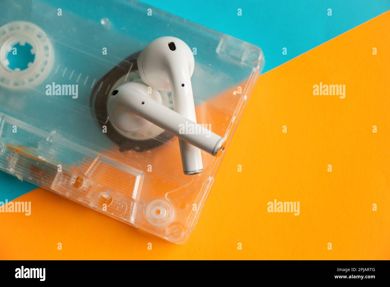 old music cassette and wireless headphones on an isolated background ...