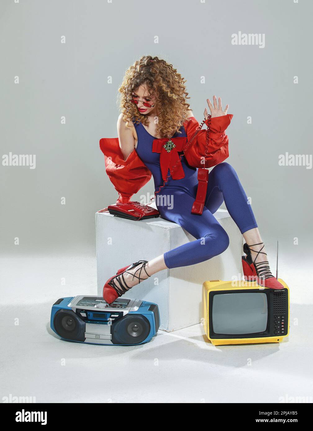 A model in a bright outfit with a two-cassette tape recorder poses in ...