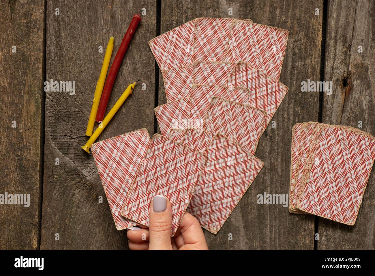 cards in the hands of a fortune teller and candles on the table ...