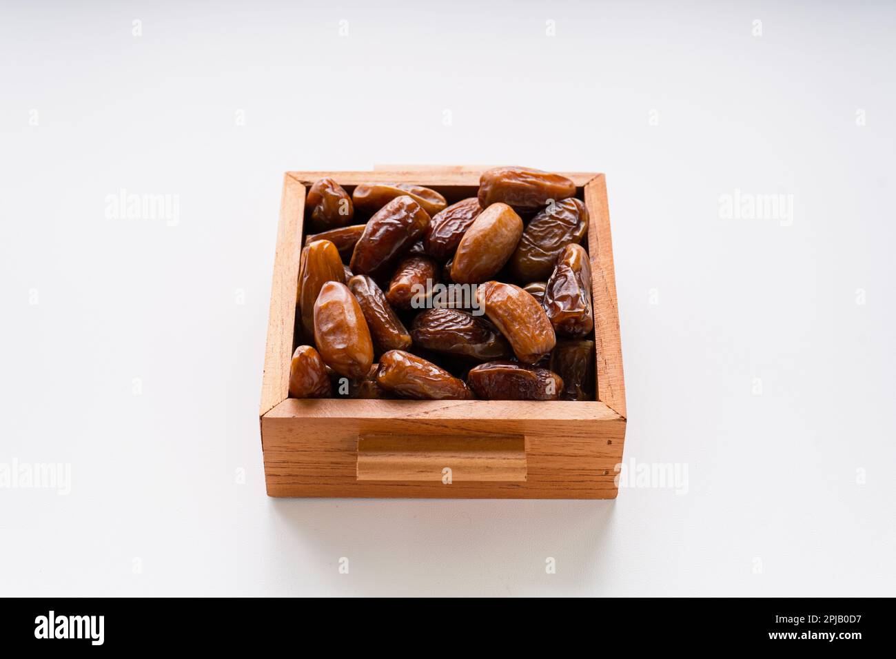 Dried dates fruit in wooden tray with soft napkin isolated on white ...