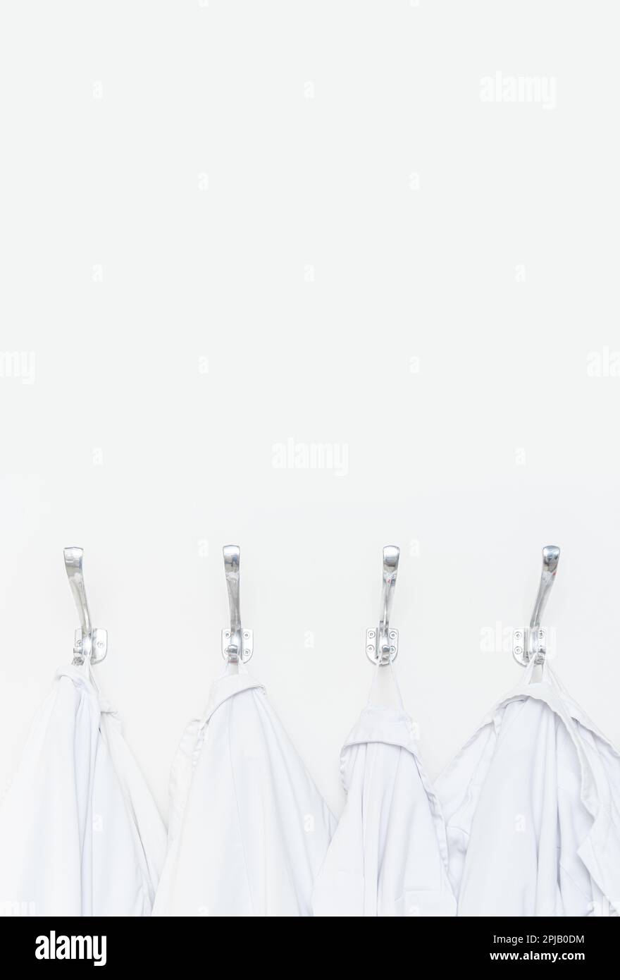 White lab coats or doctors coats hanging on the wall of a laboratory ...
