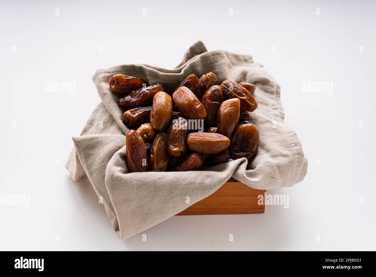 Dried dates fruit in wooden tray with soft napkin isolated on white ...