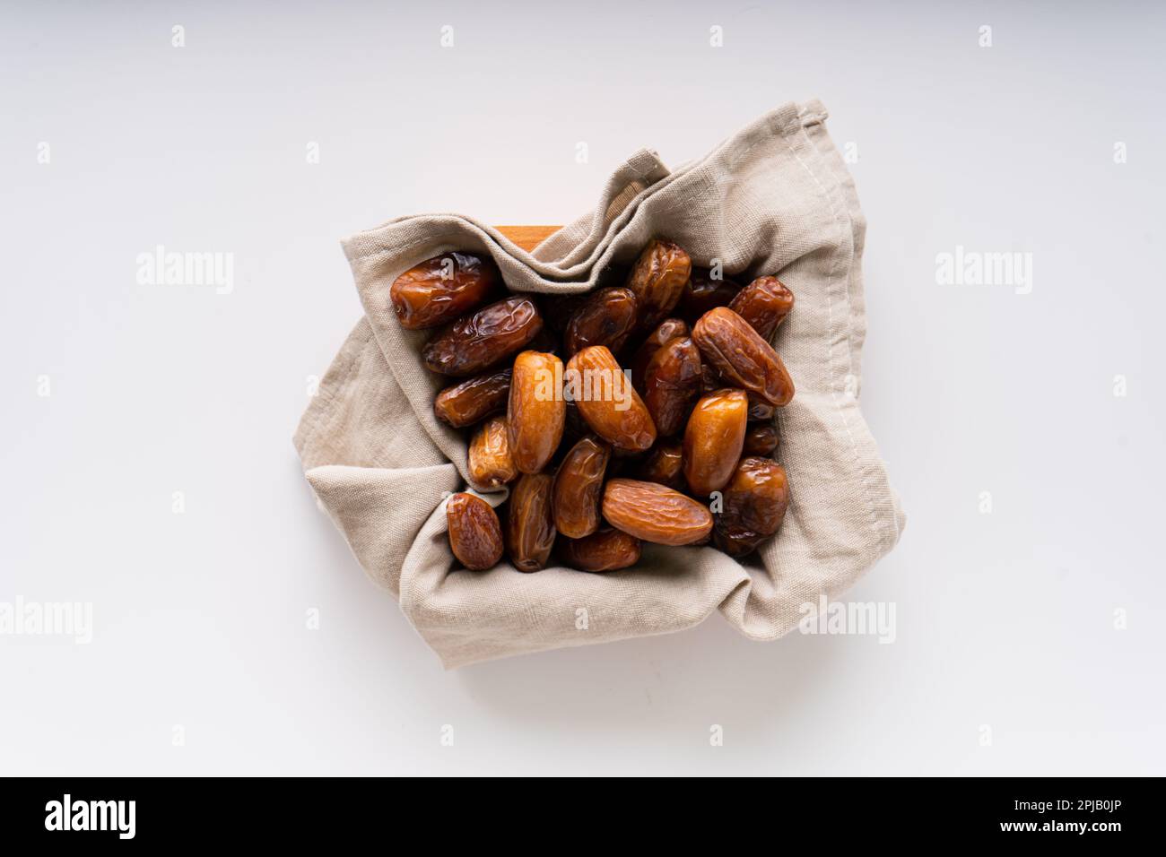 Dried dates fruit in wooden tray with soft napkin isolated on white ...