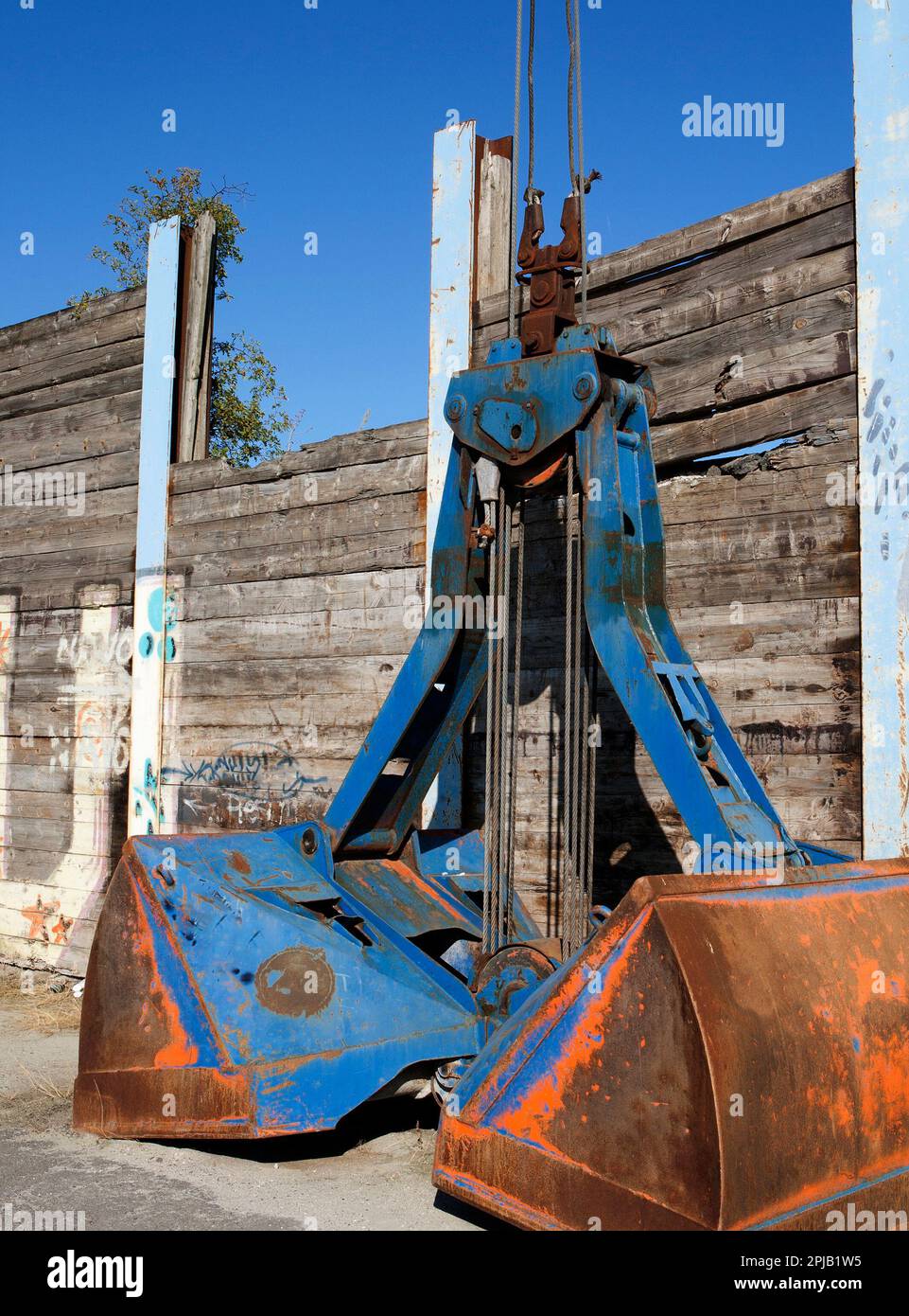 Heavy blue rusty grab on a crane Stock Photo - Alamy