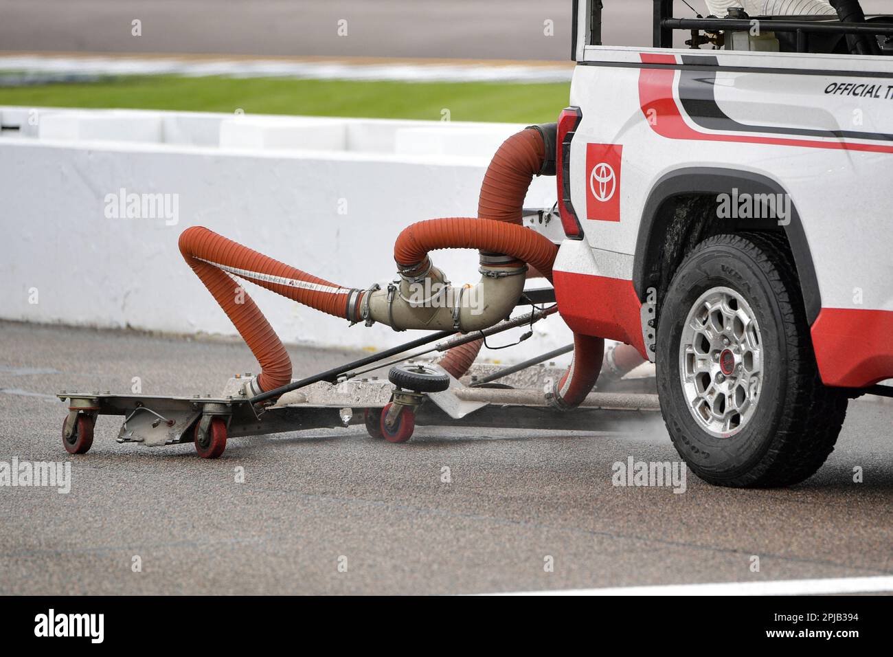 A truck from the track drying team helps dry pit road before the start ...