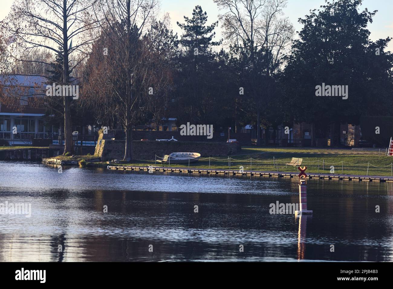 Lakeshore in a residential area at sunset with reflection casted in the ...