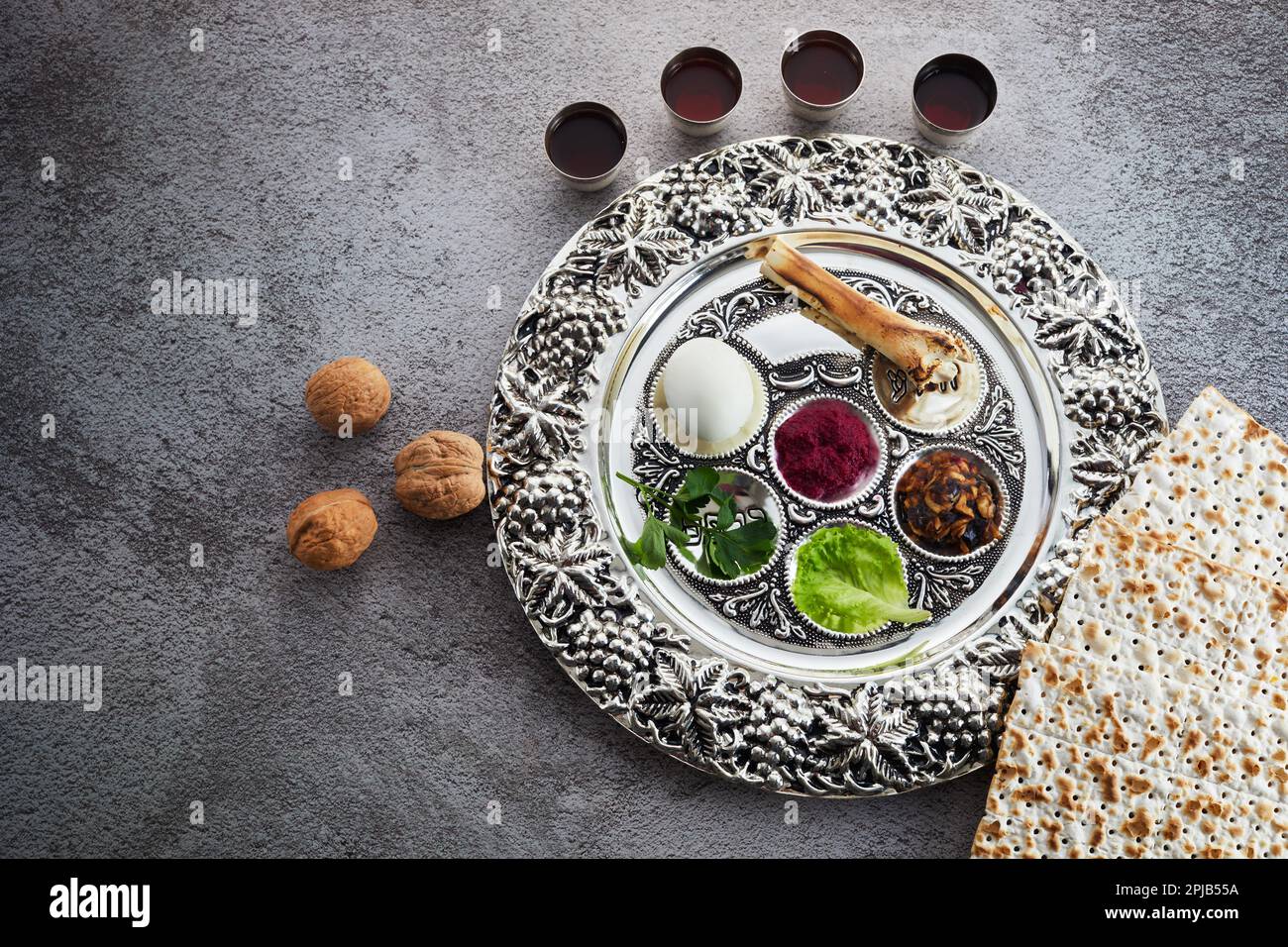 Passover Seder plate with traditional food, walnuts, matza and wine on ...