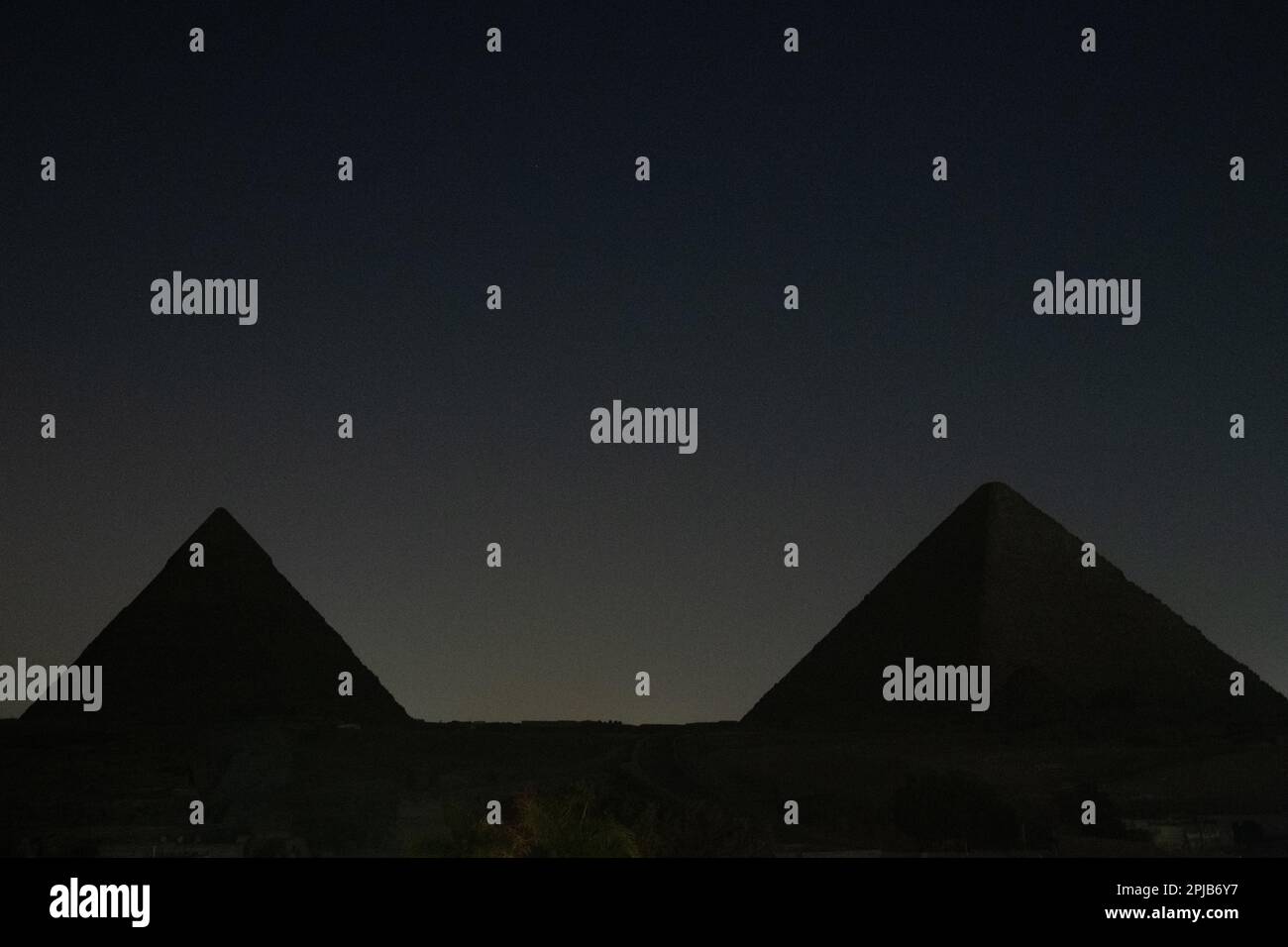 The silhouettes of the Pyramids of Giza at night in Egypt Stock Photo ...