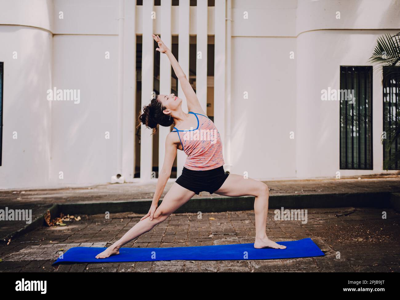 Young woman doing reverse warrior yoga outdoors. Girl doing yoga ...