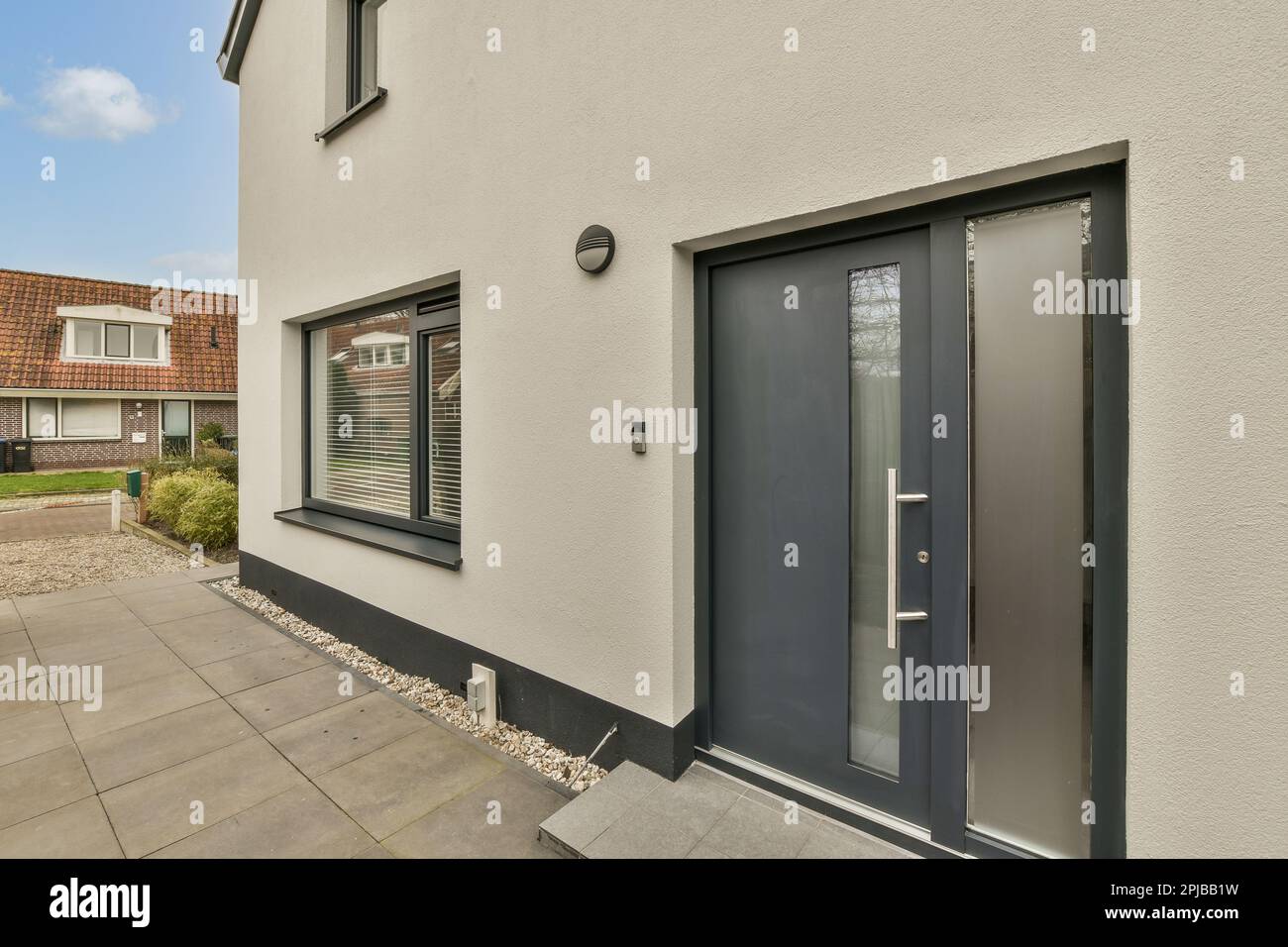 an outside view of a house with grey doors and black shutters on the ...