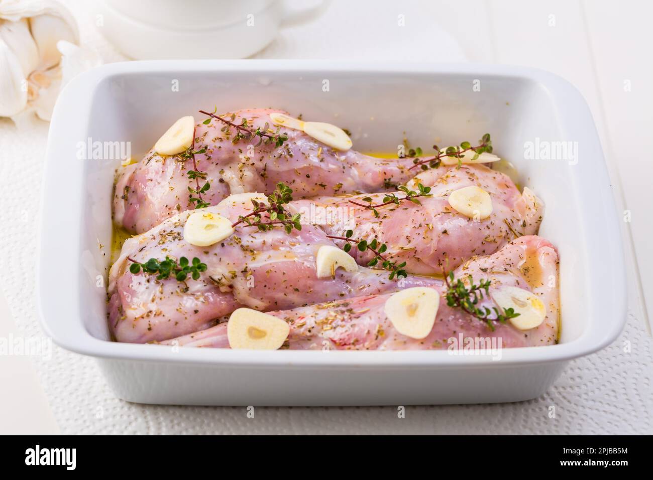 Marinated rabbit legs with lemon, garlic and herbs in the casserole ...