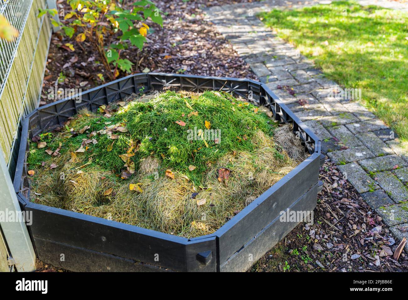 Making compost in composting bin in small garden Stock Photo - Alamy