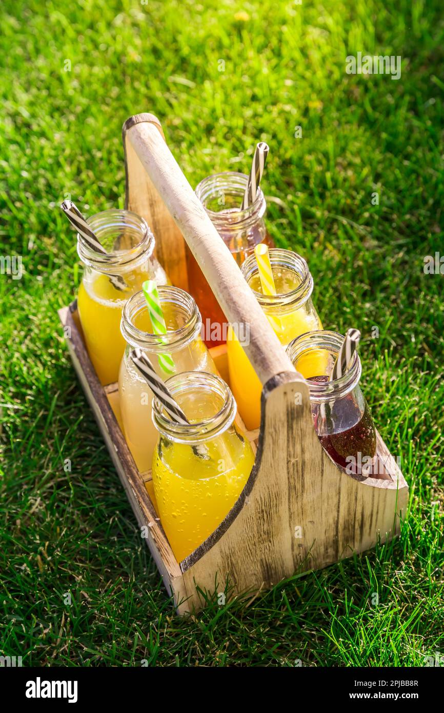 Assortment of lemonade and ice tea in bottles in wooden rack in the ...