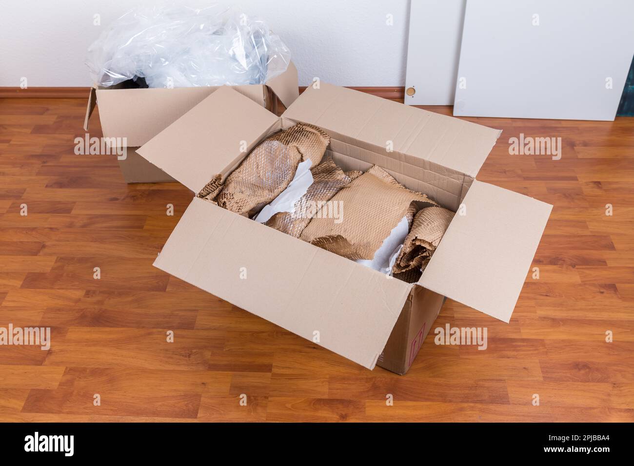 Moving boxes with packing material for fragile items on the floor ...