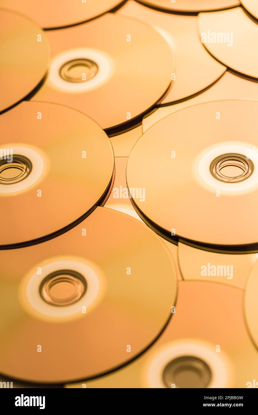 CDs and DVDs in golden tone as background. Soft focus Stock Photo - Alamy