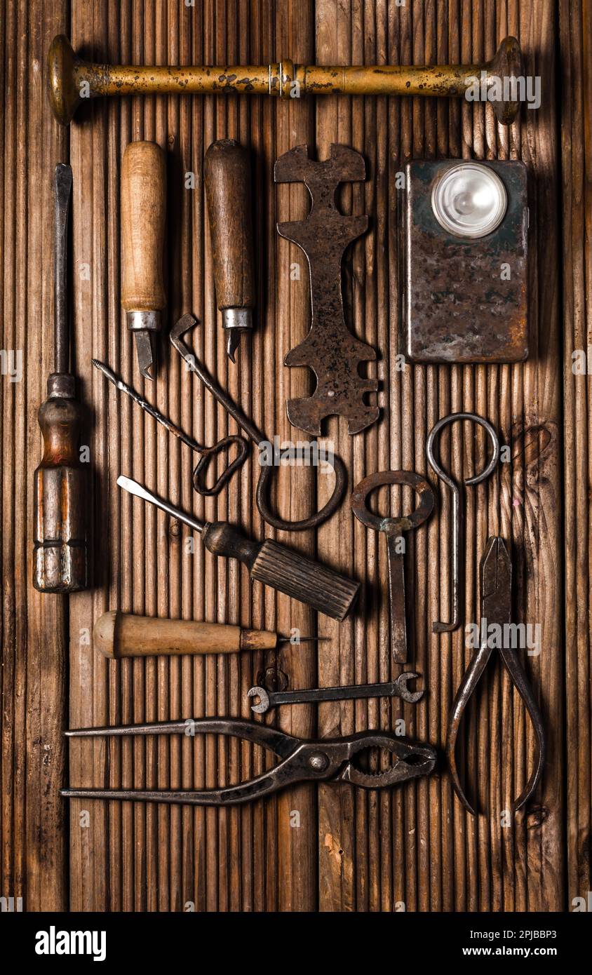 Collection of rusty tools and keys in vintage style on wooden ...