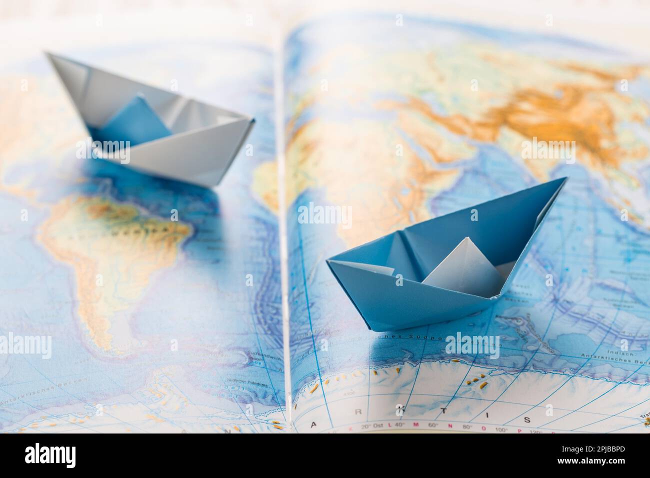 Small paper boats on world map. Concept of traveling or military ...