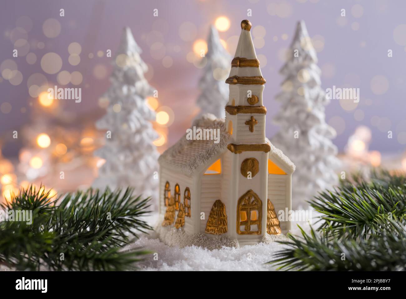 Small church with candles and white trees as snowy landscape. Christmas ...