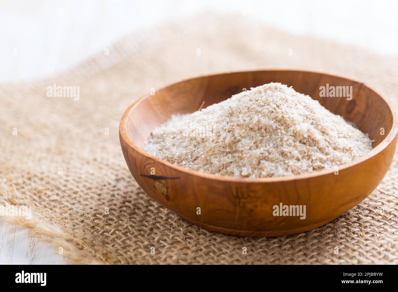 Heap of psyllium (Plantago ovata) husk in wooden bowl on wooden table ...