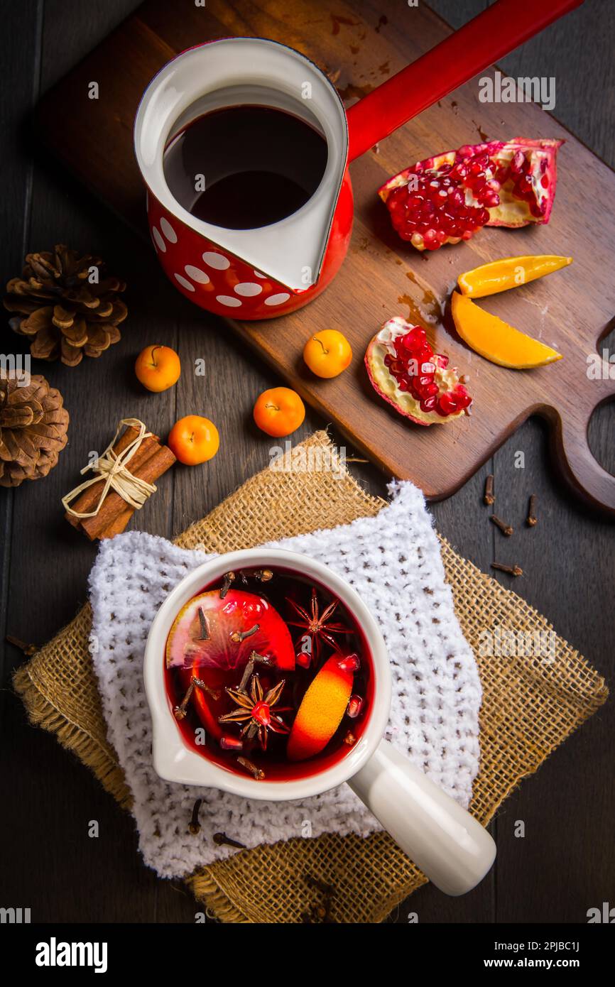 Hot spicy mulled wine with fruits and spices in mug for winter and ...