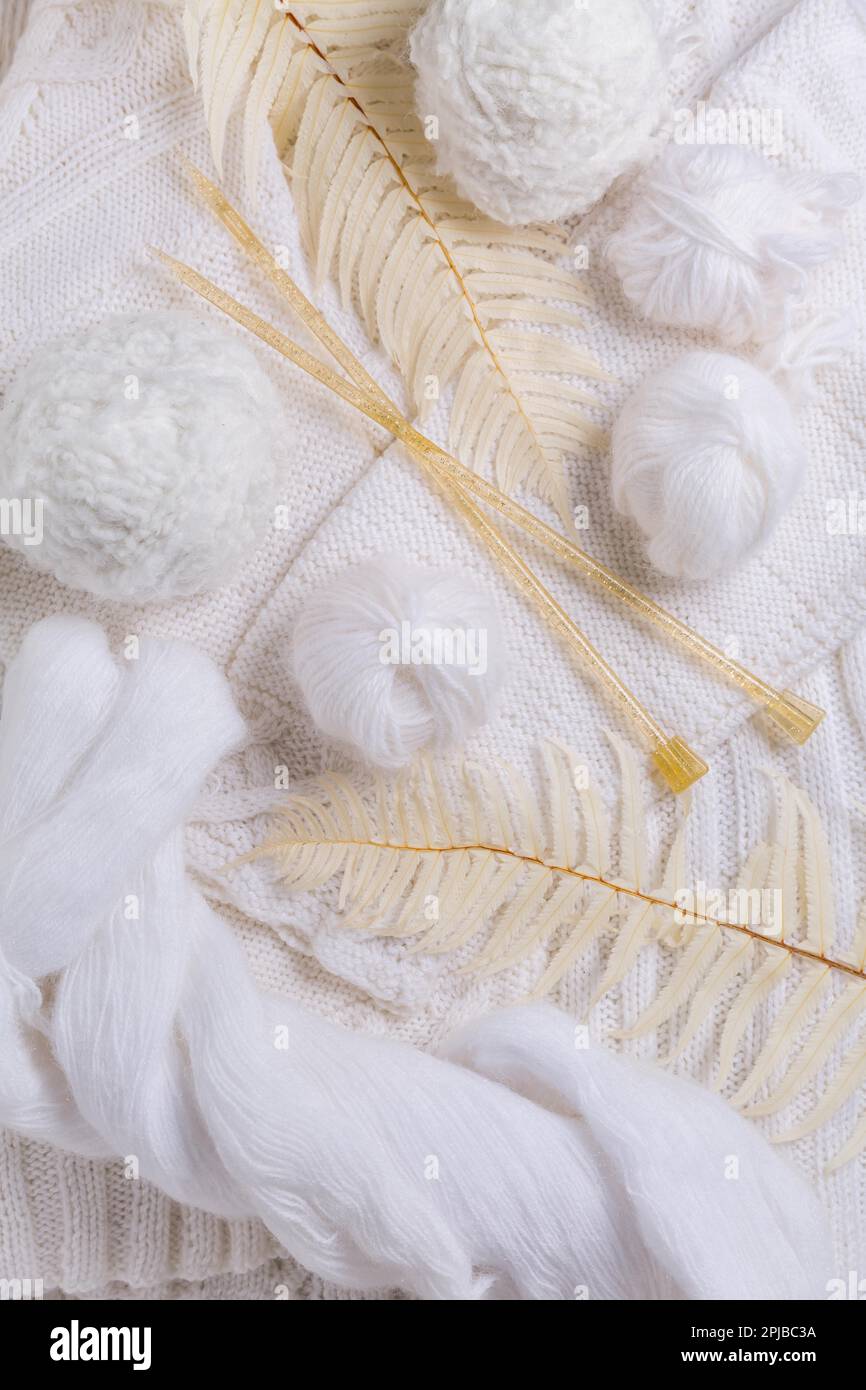 Knitting concept with needles, wool, sweater and yarn in white color ...