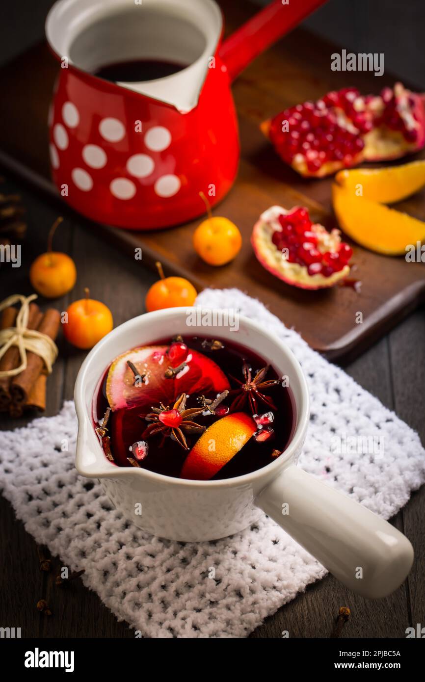 Hot spicy mulled wine with fruits and spices in mug for winter and ...