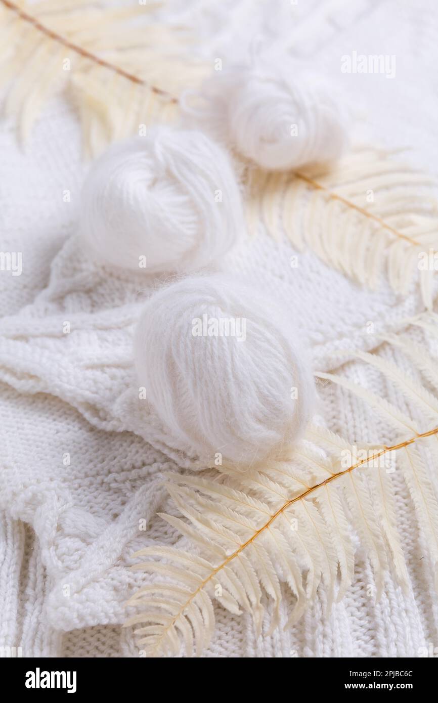 Knitting concept with needles, wool, sweater and yarn in white color ...