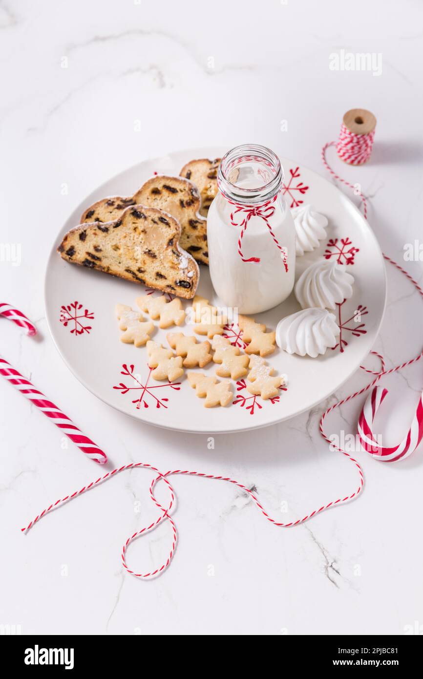 Bottle of milk with traditional Christmas stollen, small cookies and ...