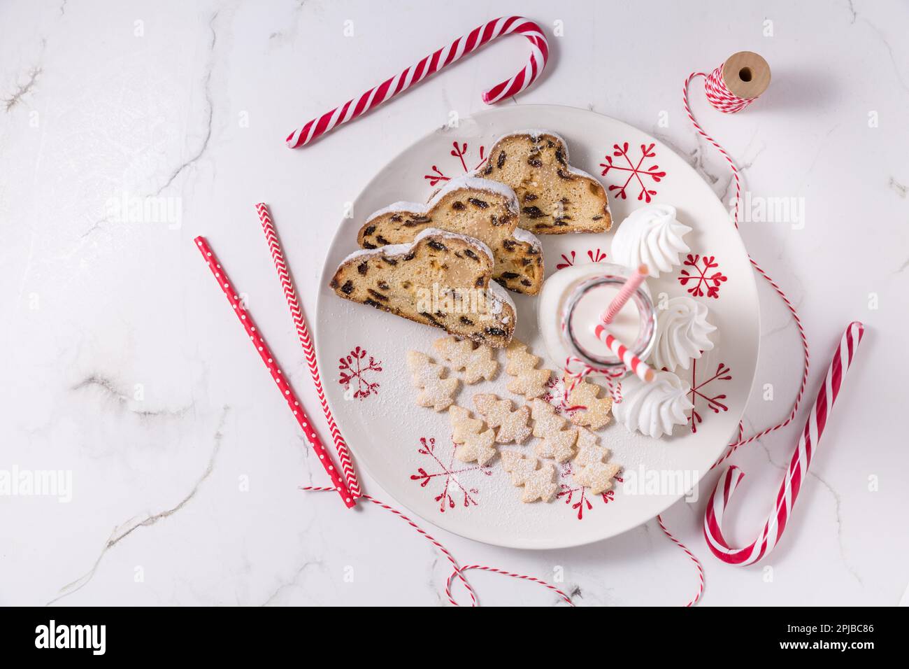 Bottle of milk with traditional Christmas stollen, small cookies and ...