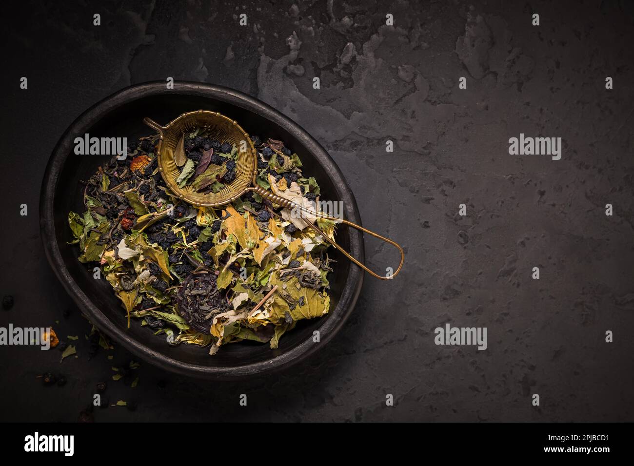 Mixture of teas, dried organic tea herbs and fruits in bowl with tea ...