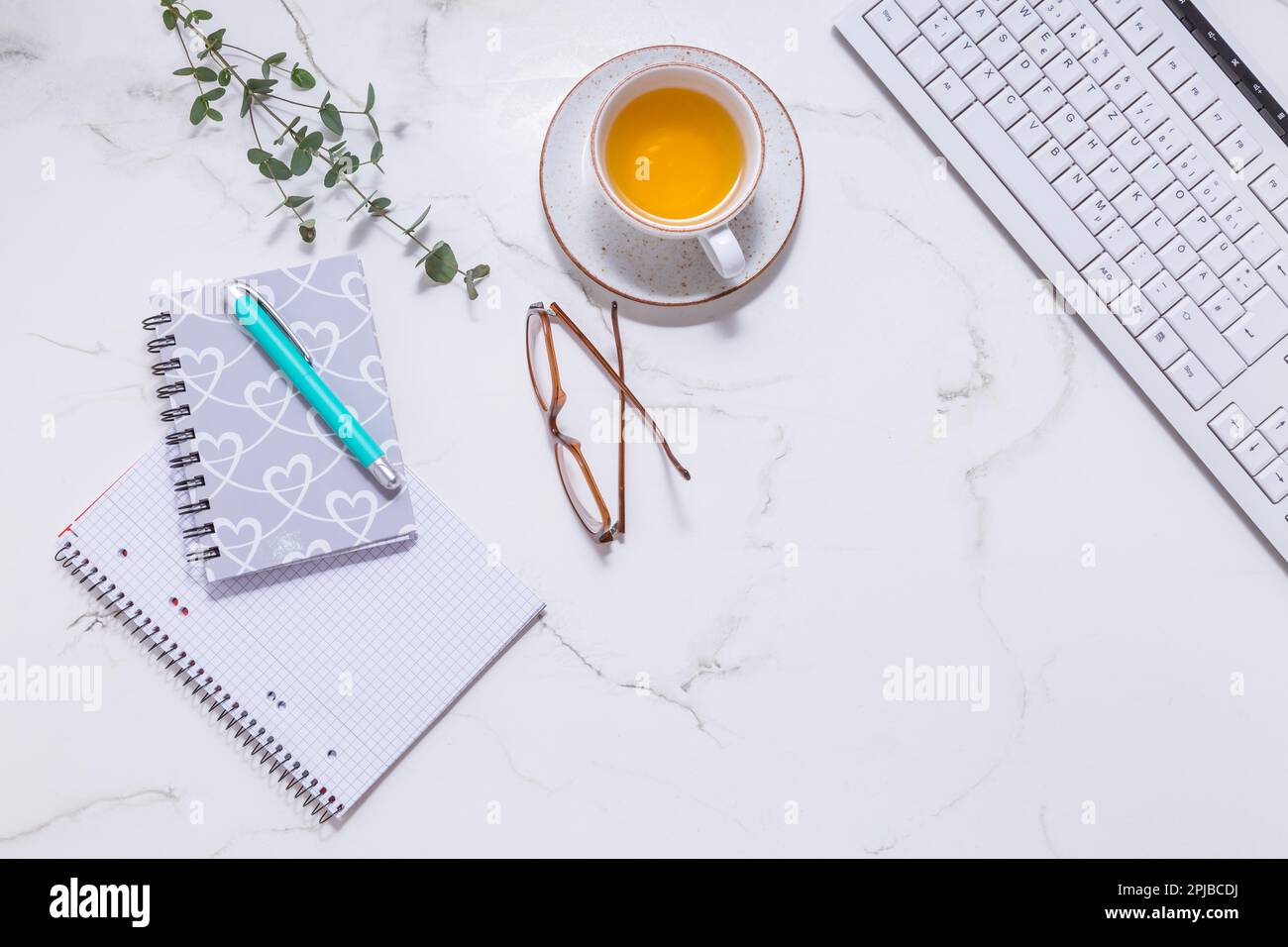 Flat lay home business desk with communication device with cup of tea ...