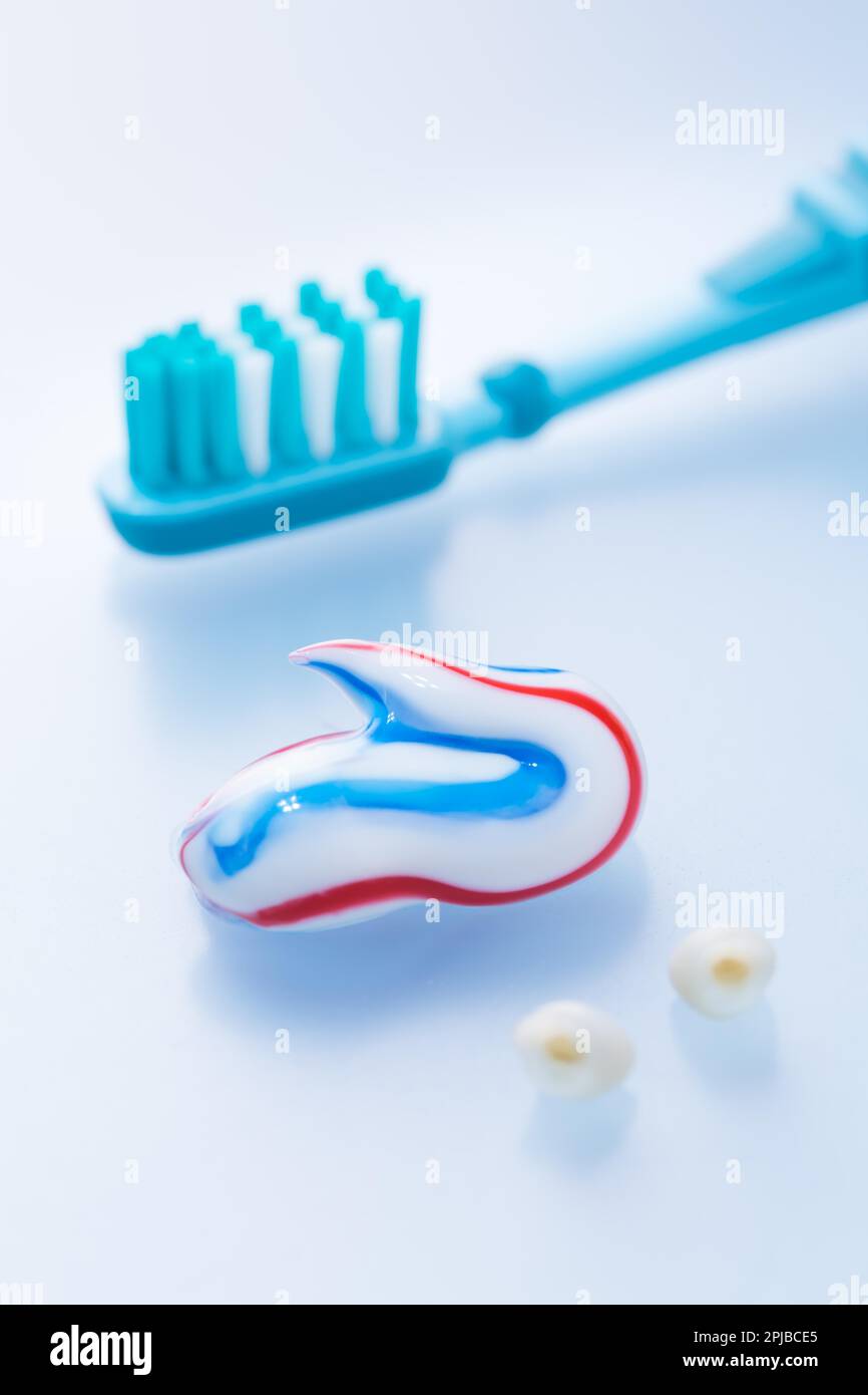 Colorful toothpaste and toothbrush with primary teeth on blue ...