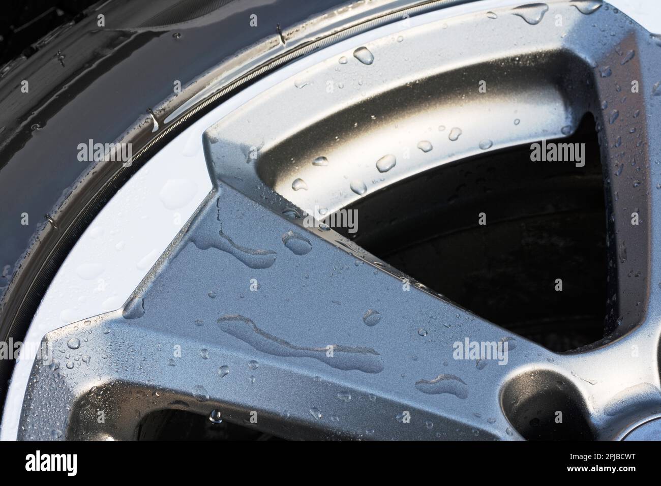 Detail shot of a modern car tyres with aluminium rims and water ...