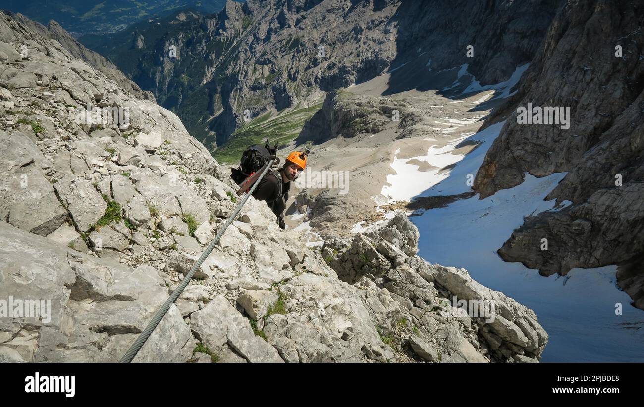 Tourist with equipment on the via ferrata trail in the alps. Zugspitze ...