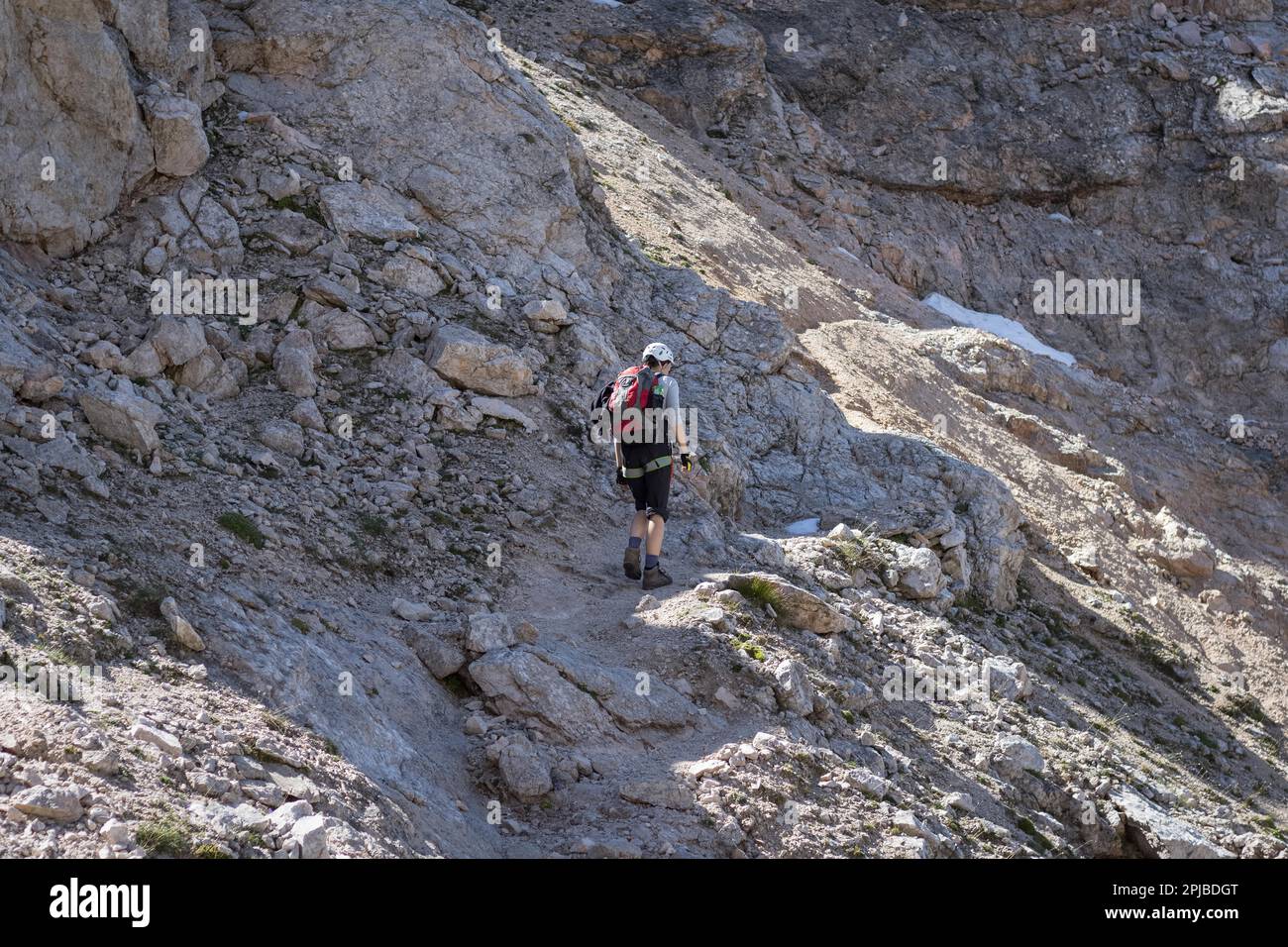 Tourist crossing the via ferrata trail with equipment in the dolomites ...