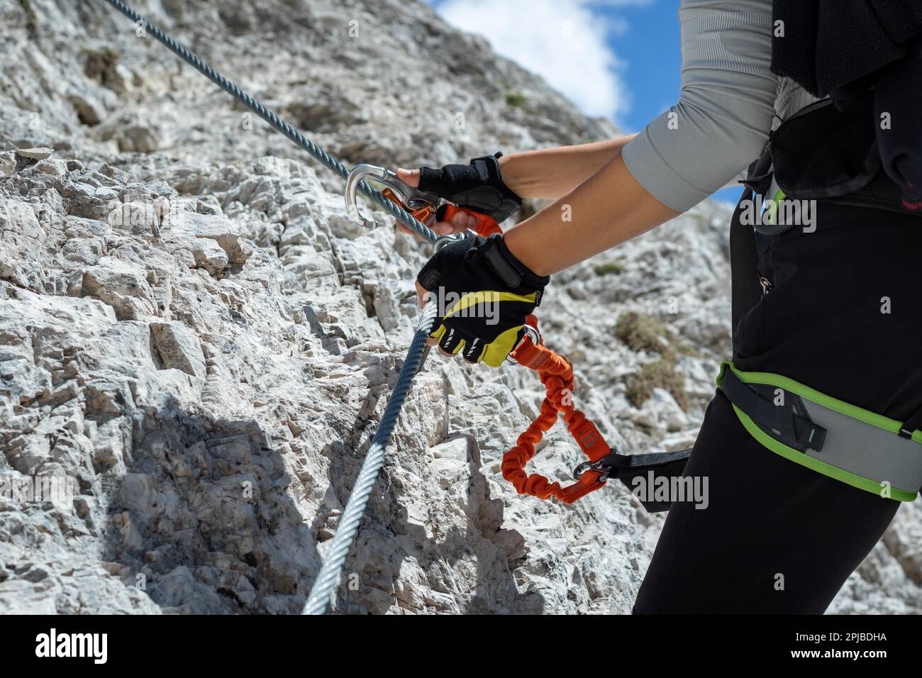 Climbing along a steel line on the via ferrata route in the dolomites ...