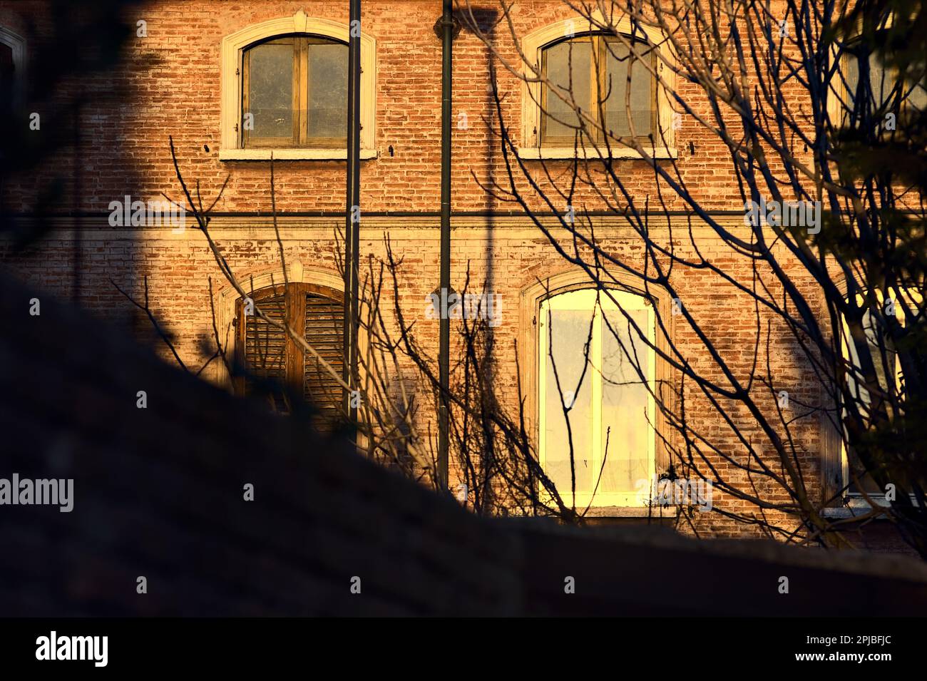 Facade of a building with a window lit by the sun at twilight Stock ...