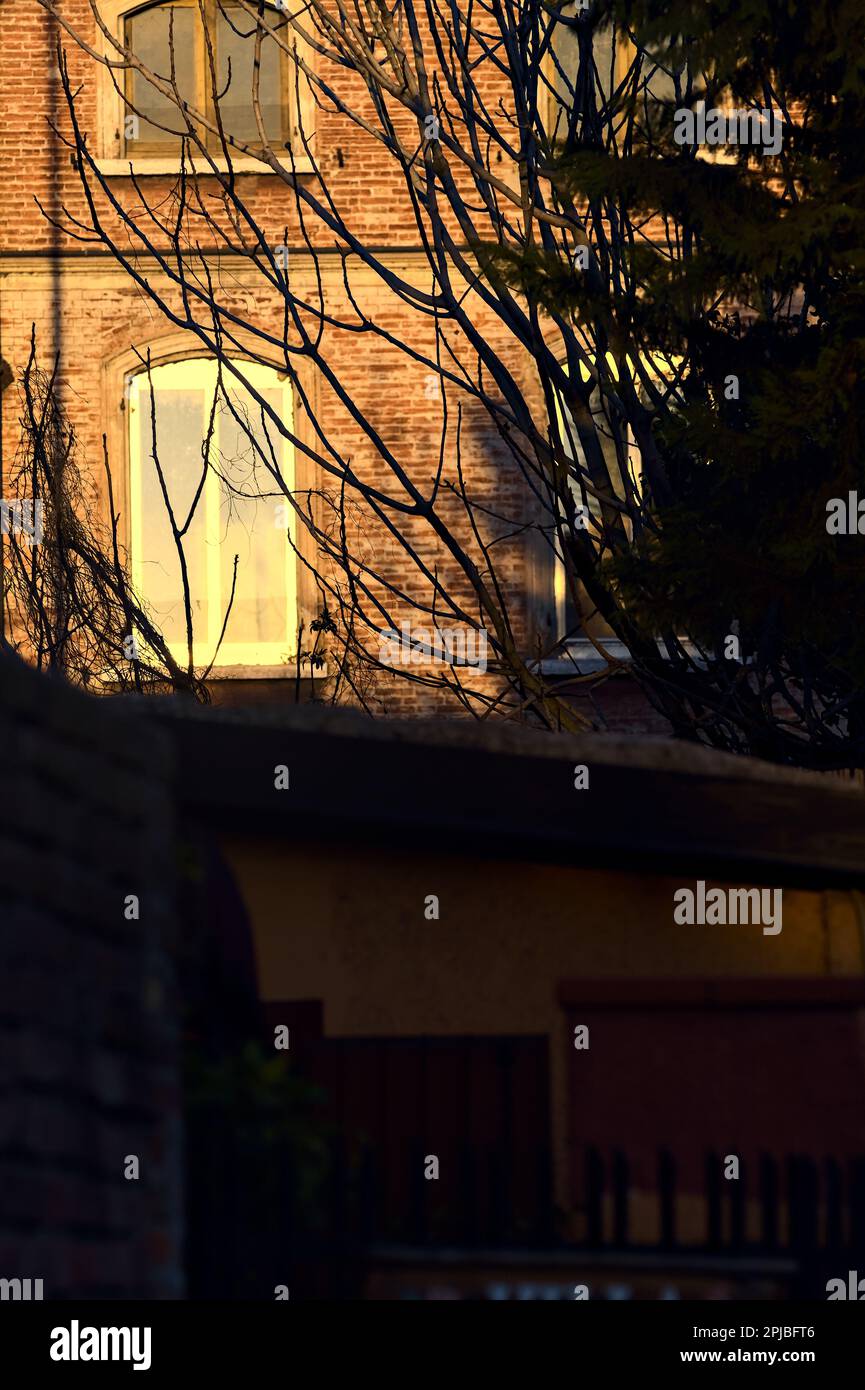 Facade of a building with a window lit by the sun at twilight Stock ...