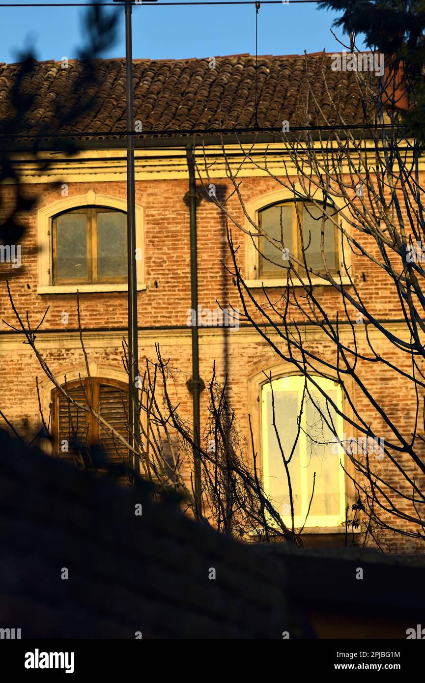 Facade of a building with a window lit by the sun at twilight Stock ...