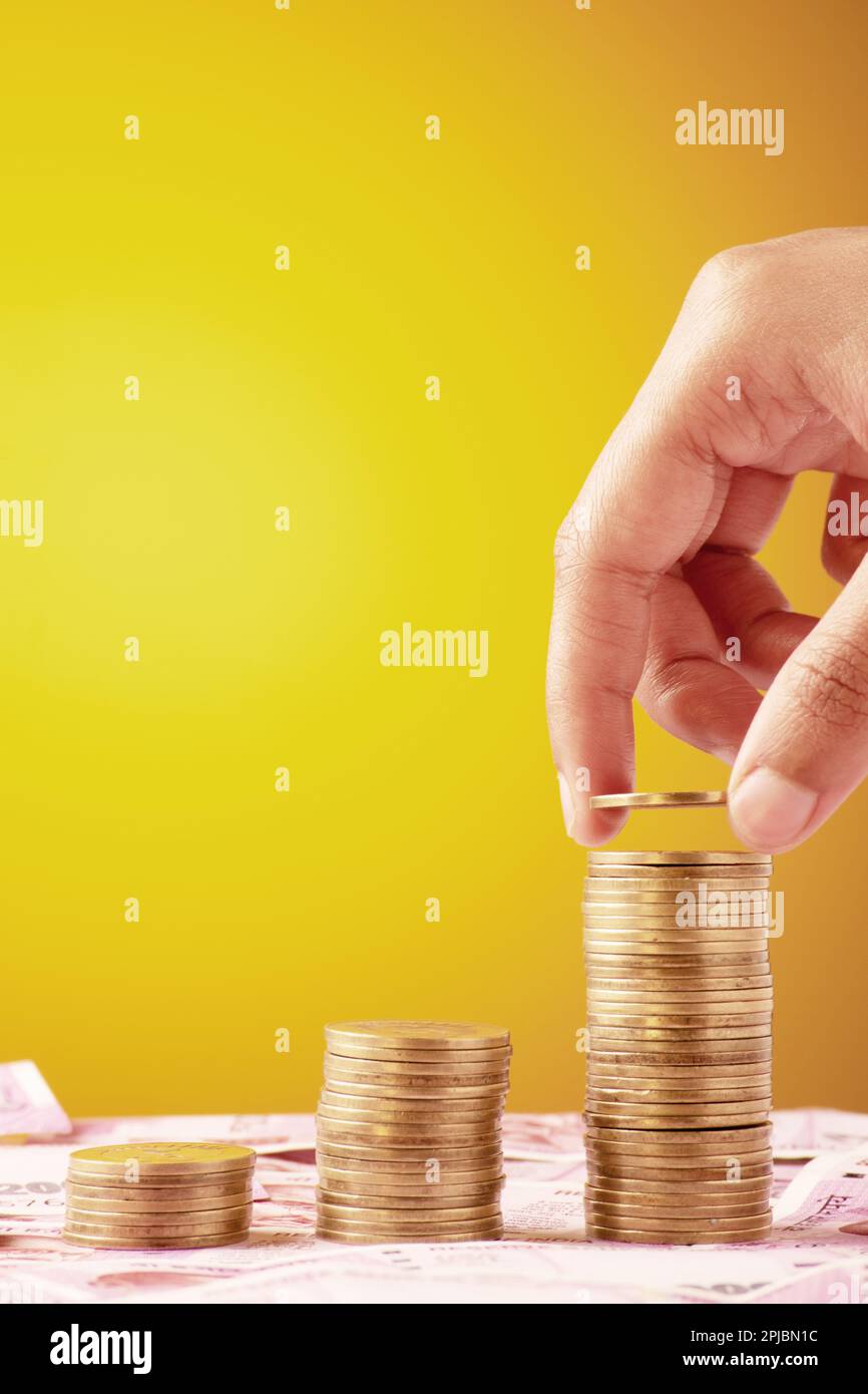 Closuep of hand put coin stack, money saving concept Stock Photo - Alamy