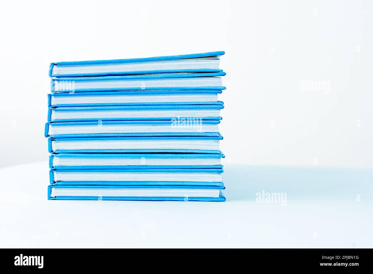 stack of blue books on a white background Stock Photo - Alamy
