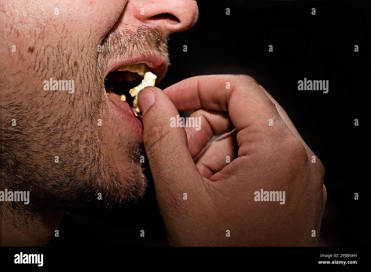 profile of a man eating popcorn Stock Photo - Alamy