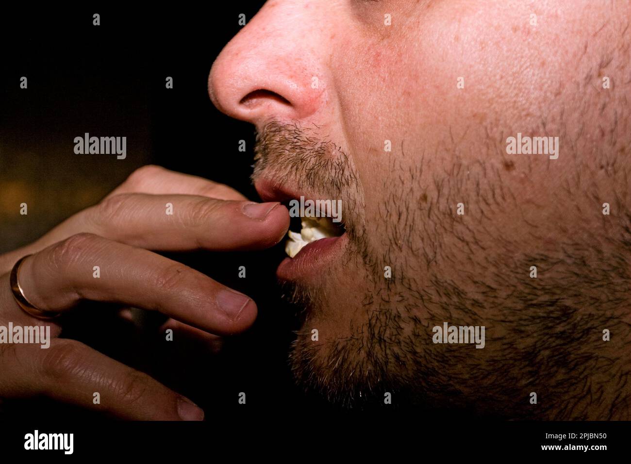 profile of a man eating popcorn Stock Photo - Alamy