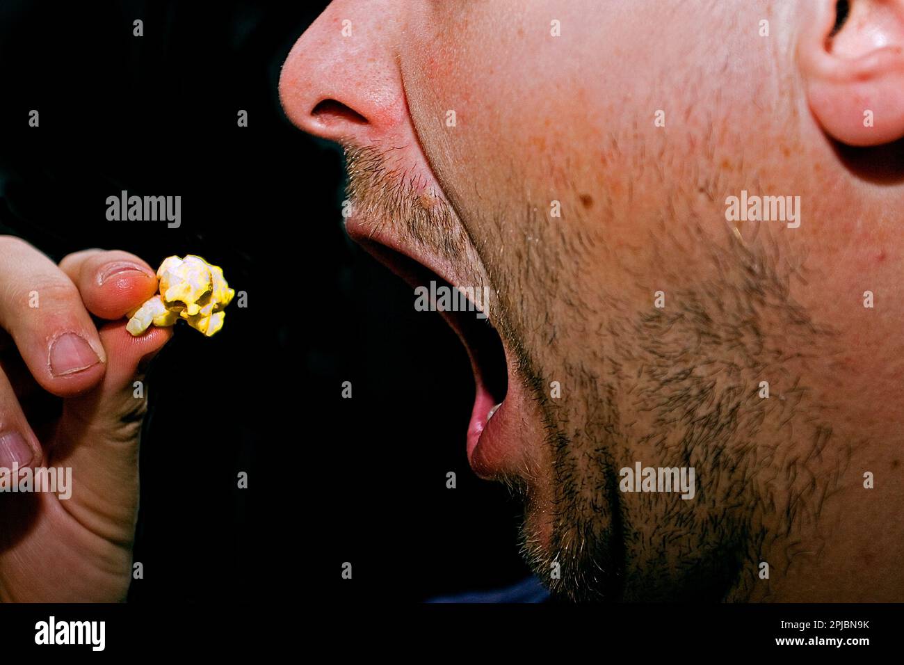 profile of a man eating popcorn Stock Photo - Alamy