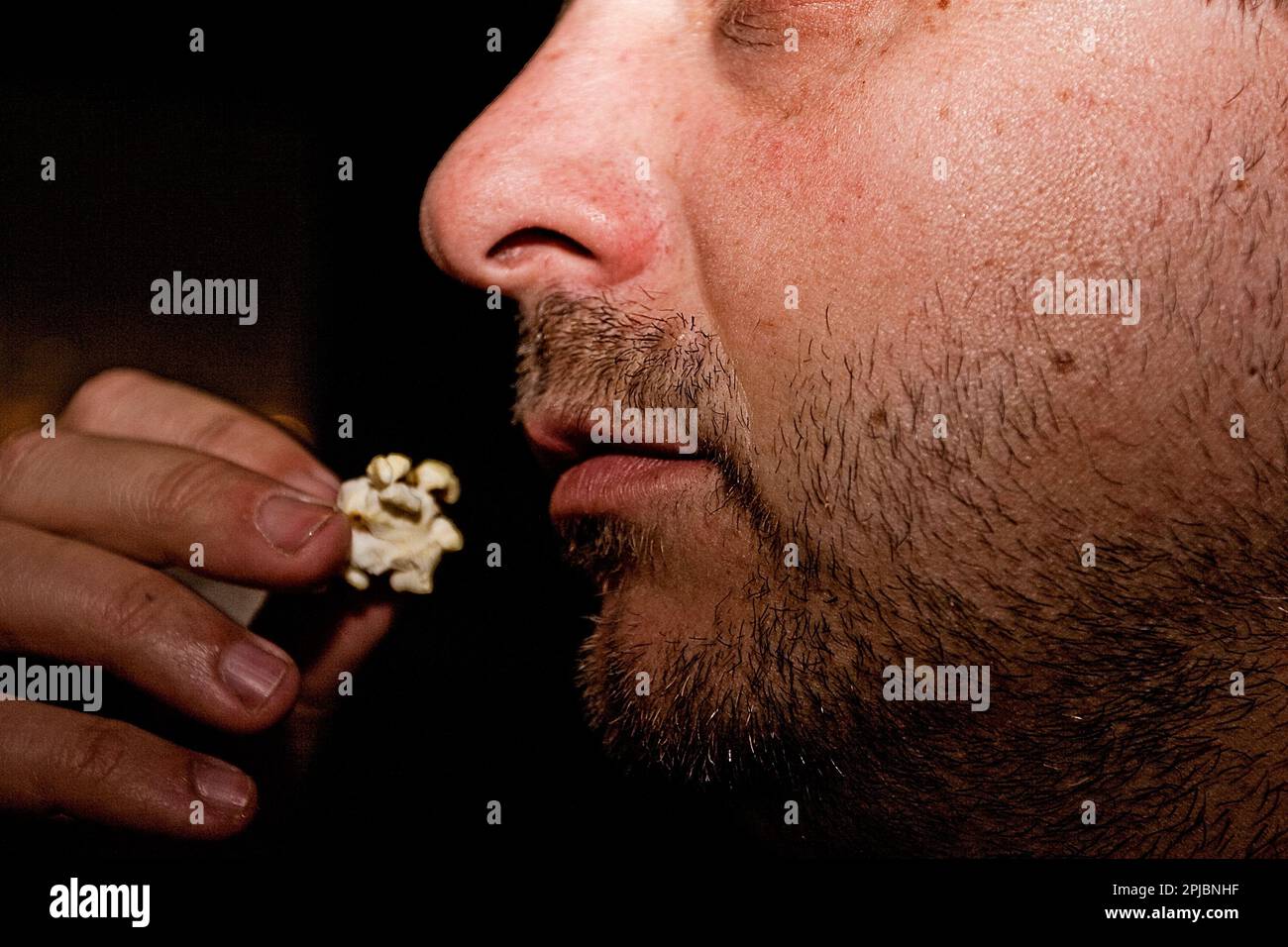 profile of a man eating popcorn Stock Photo - Alamy